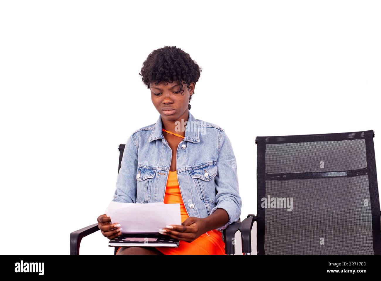 Candidate girl sitting on a chair and reading a document while waiting ...