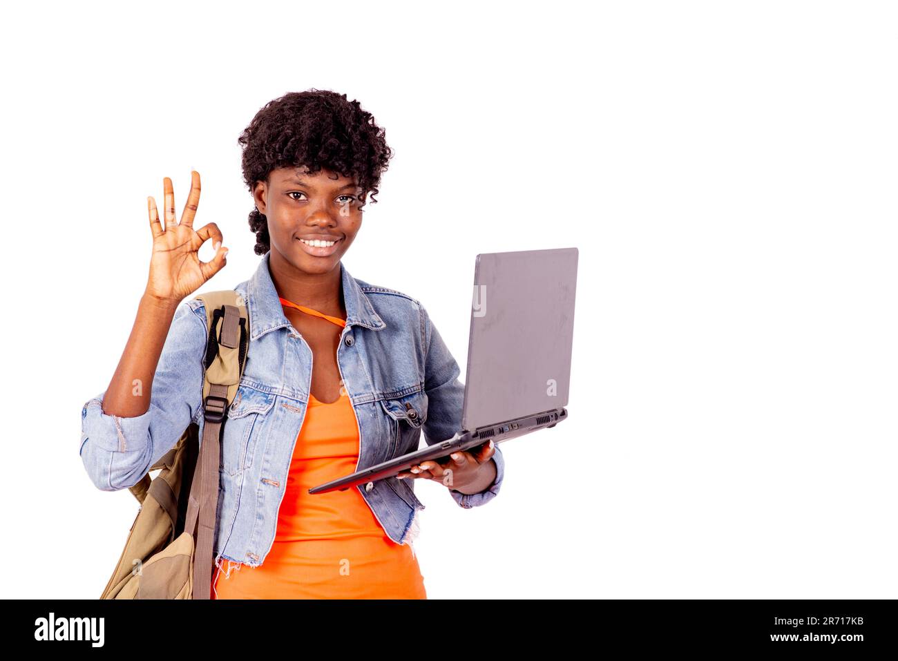 beautiful young student girl carrying backpack and holding laptop ...