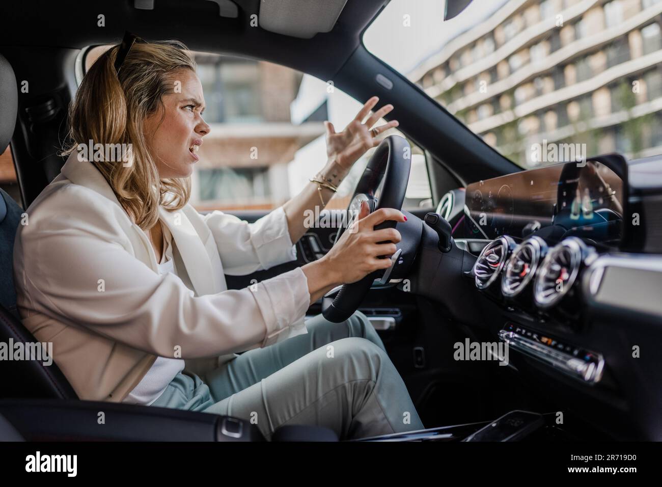Upset woman driving her car in a city Stock Photo - Alamy