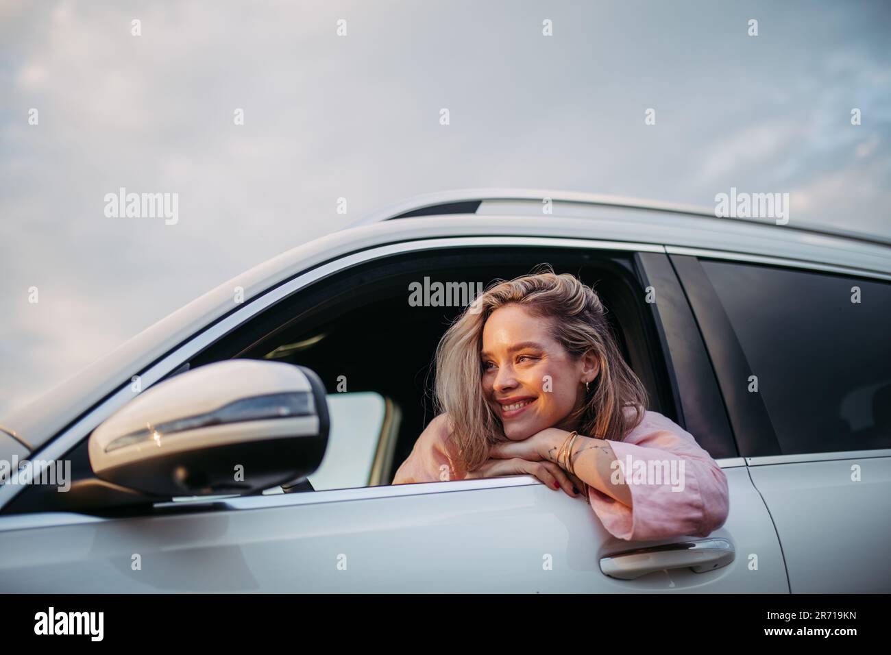 Happy woman driving her new electric car Stock Photo - Alamy