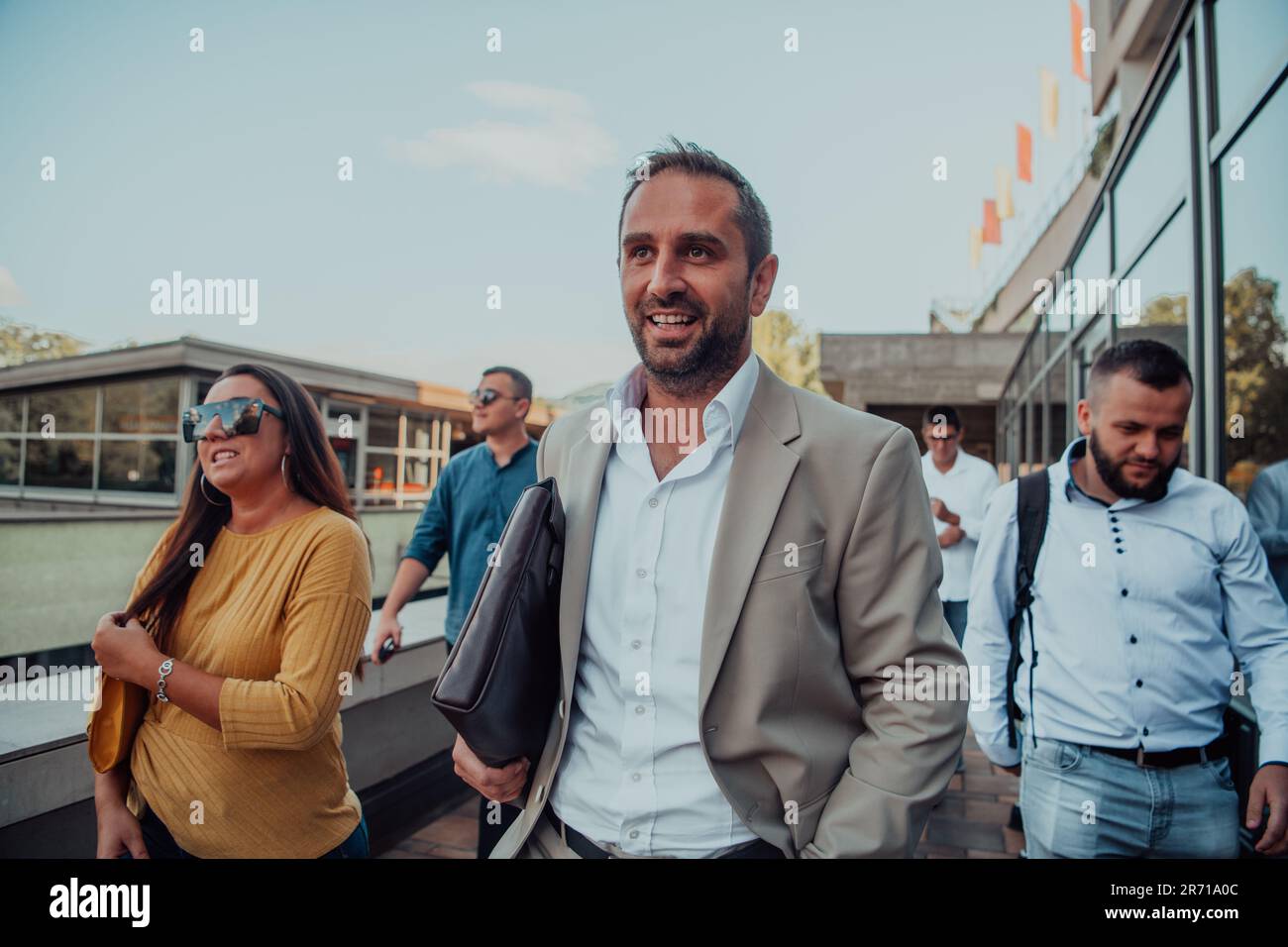 A diverse group of businessmen and colleagues walking together by their ...