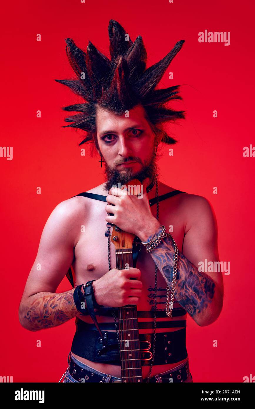 Deep look. Portrait of creative young man, punk, musician posing with ...