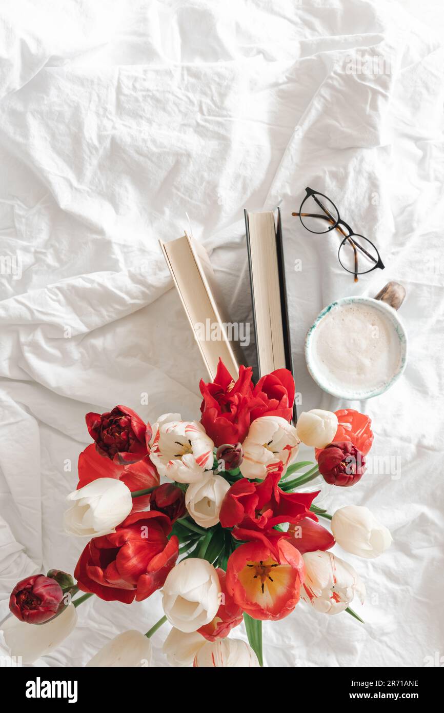 Spring background with a bouquet of tulips, a cup of coffee and books ...