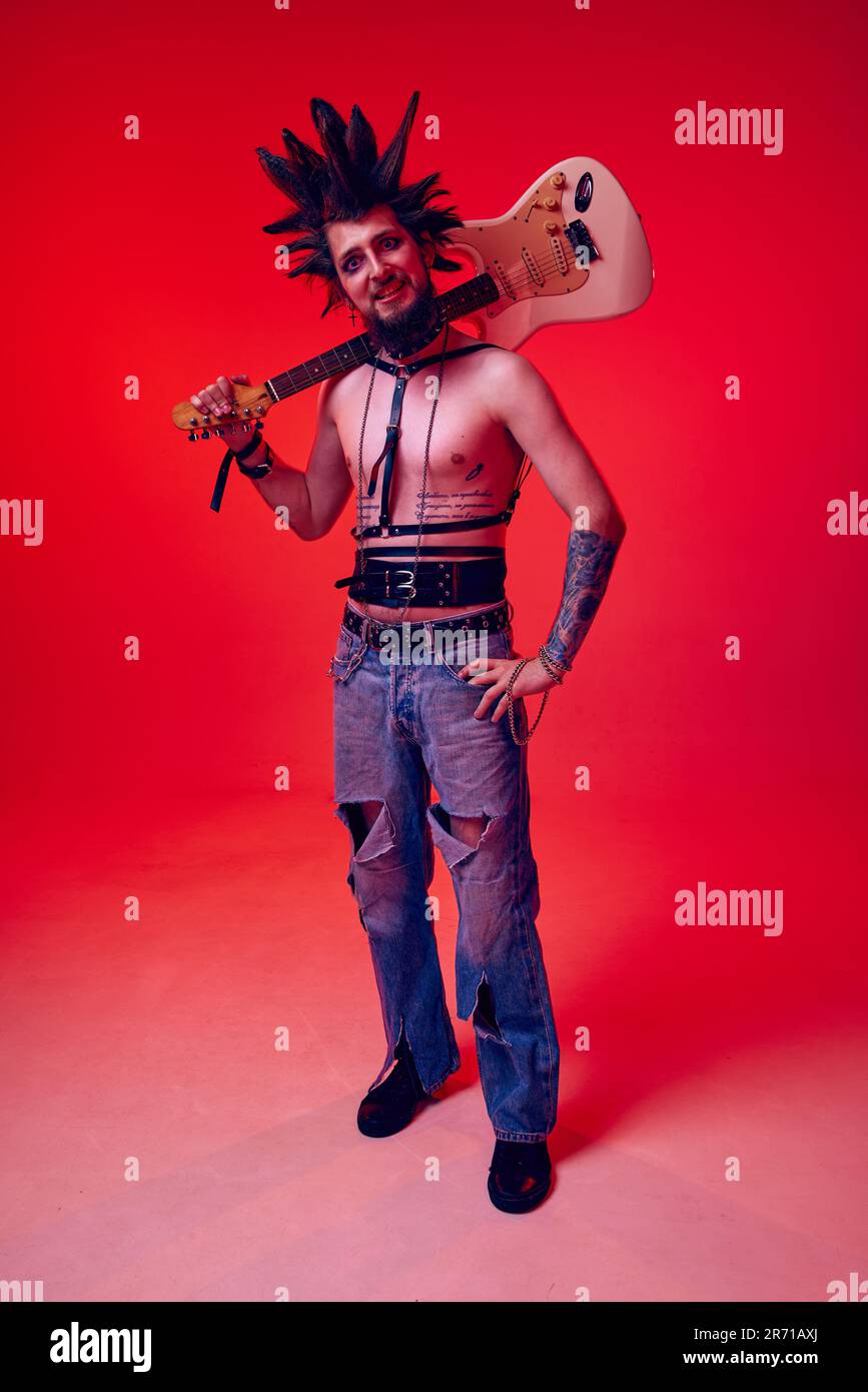 Portrait of creative young man, punk, musician posing with electric ...