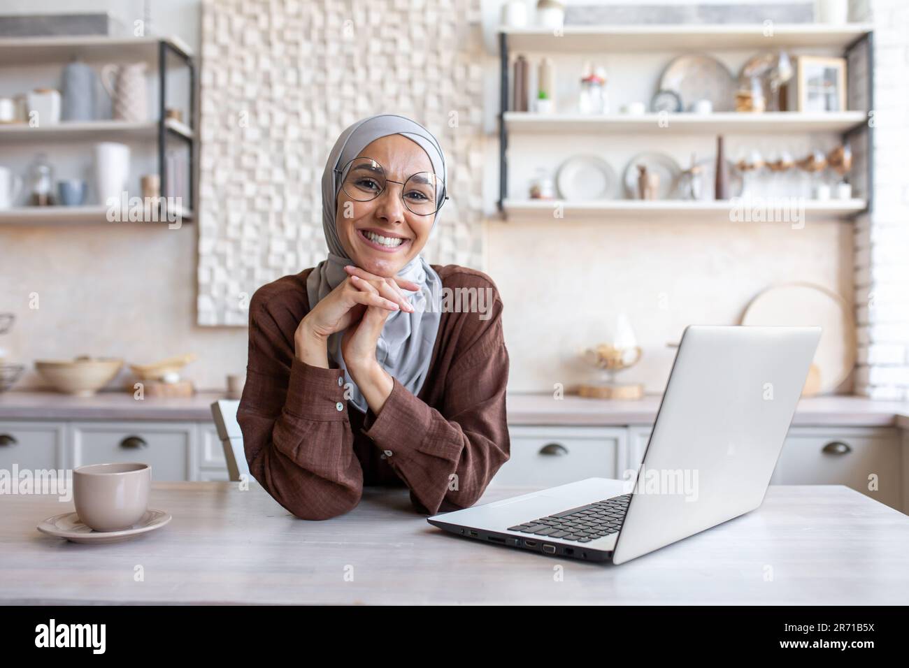 Portrait of a young beautiful Muslim female student in a hijab studying ...