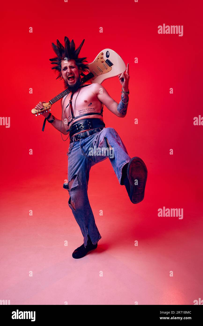 Portrait of creative young man, punk, musician posing with electric ...