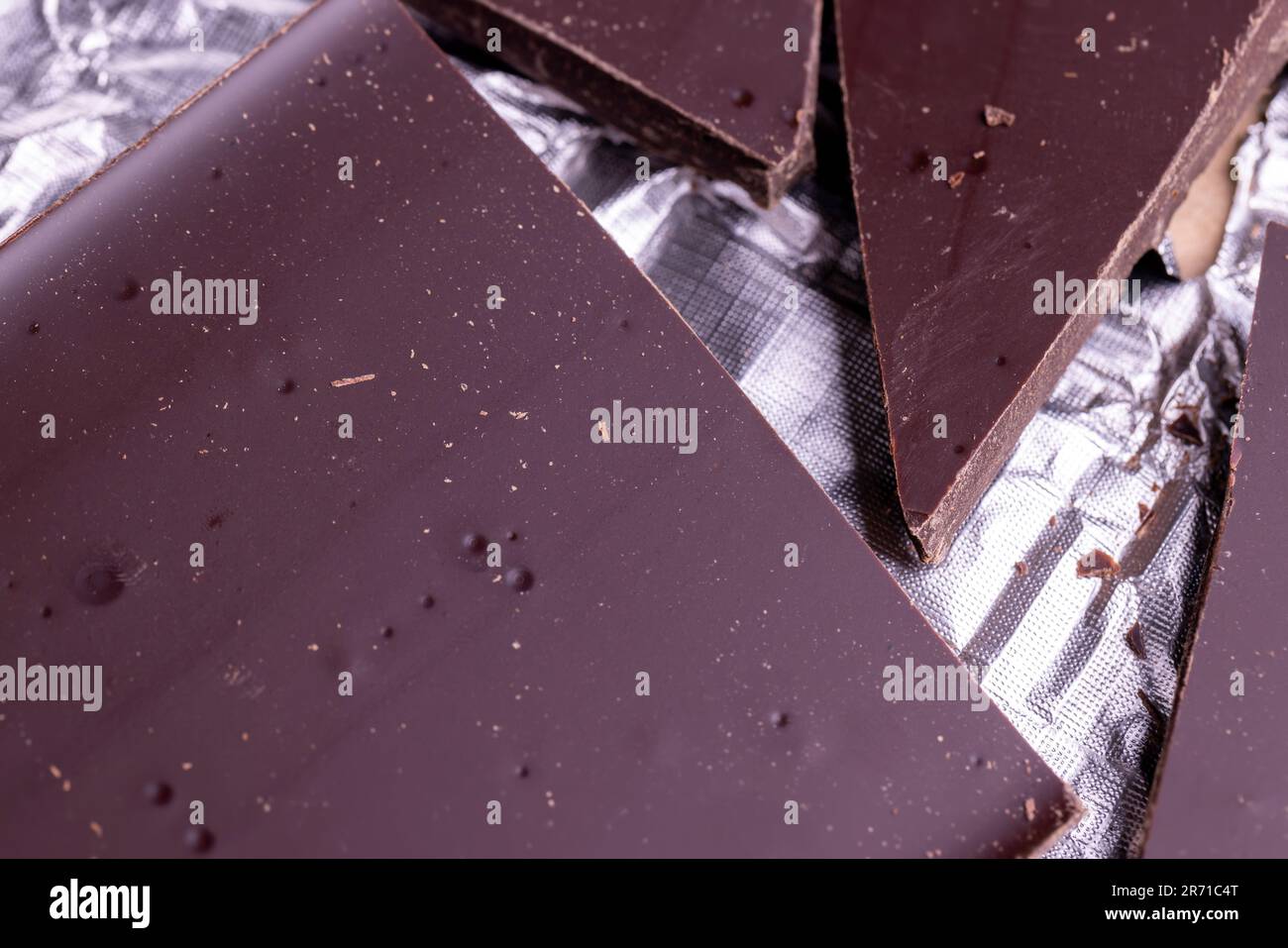 A broken chocolate bar in a paper and foil package, a sweet chocolate ...