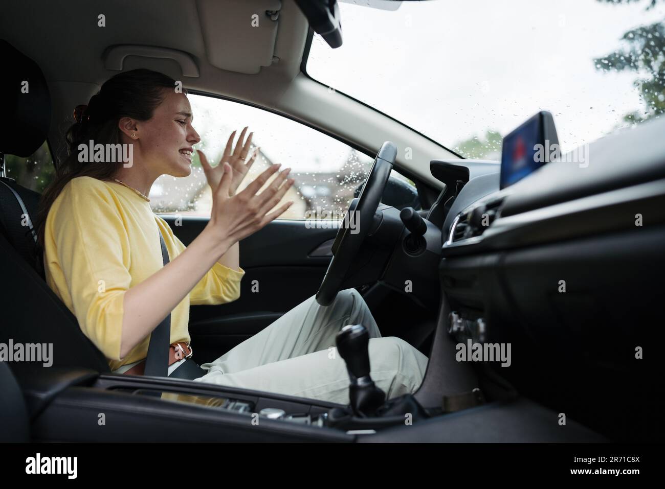 Angry woman sitting in electric car with drained battery Stock Photo ...