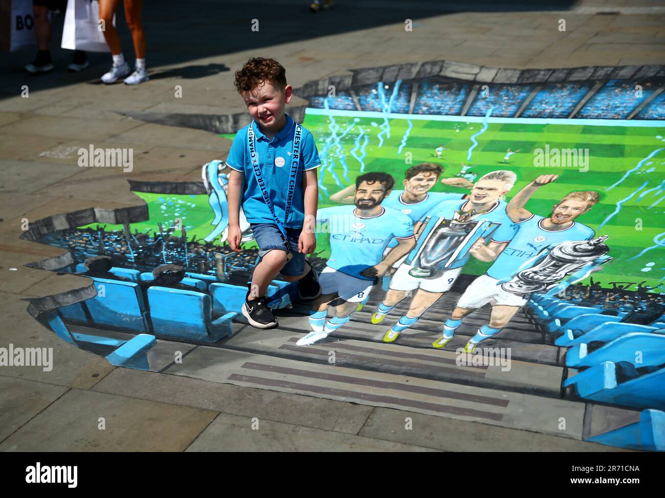 A young fan poses next to a mural on New Cathedral Street depicting ...