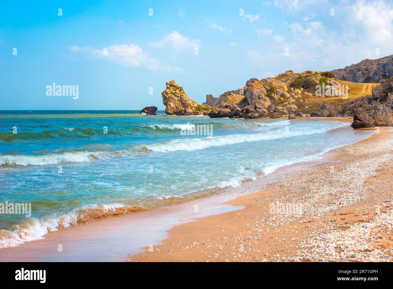 Seascape. Blue sea and rocky shore with yellow sandy beach. Sea of Azov ...