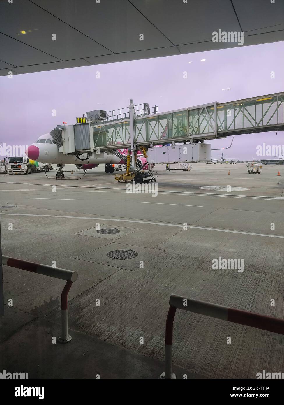 A commercial jet aircraft stands on the tarmac with its open door ...