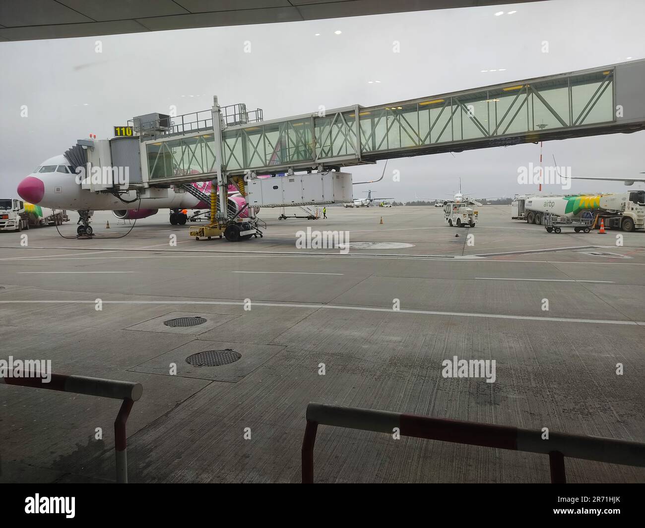 A commercial jet aircraft stands on the tarmac with its open door ...