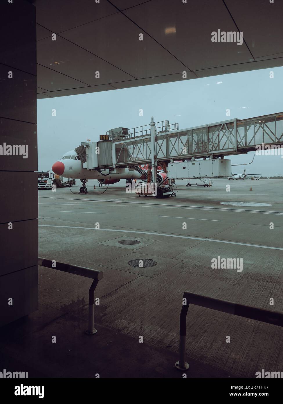 A commercial jet aircraft stands on the tarmac with its open door ...