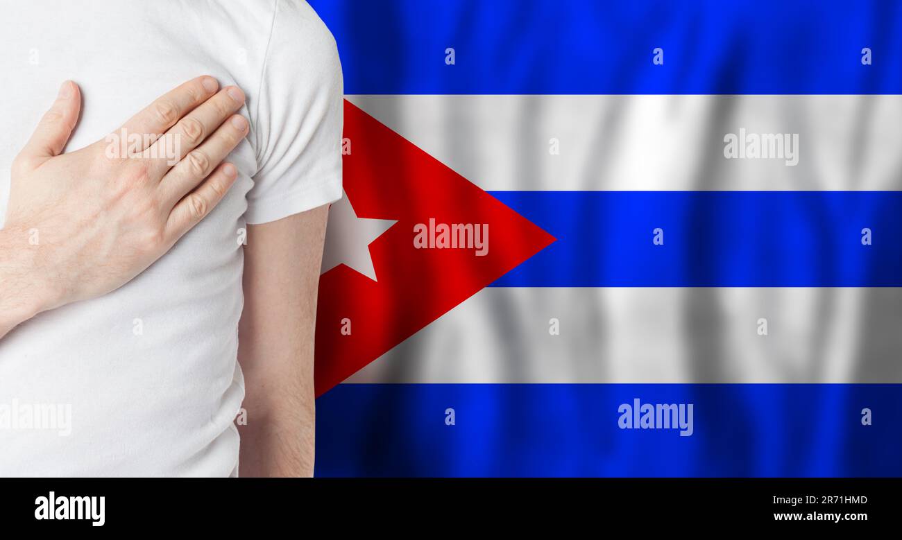 Cuban person with hand on heart on the background of Cuba flag ...