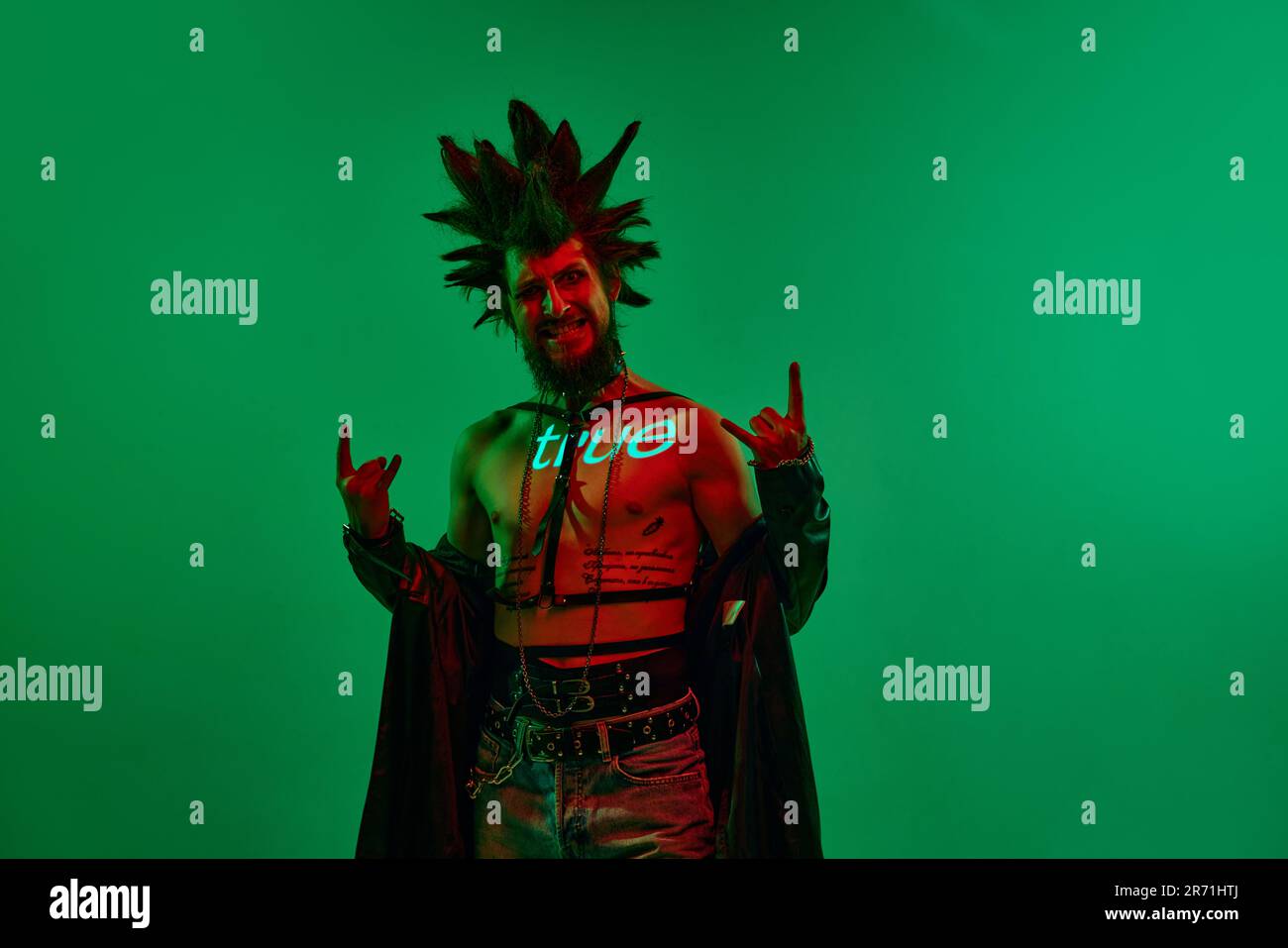 Expressive young man, rock musician, punk with neon filter on body ...