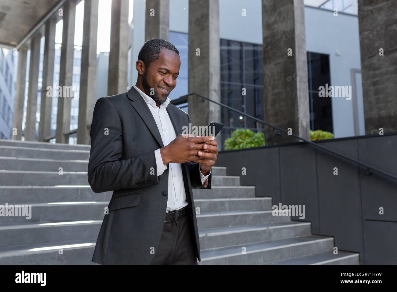 Successful african american boss businessman uses a telephone, man types messages and browses ...