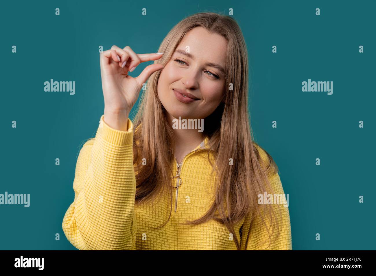 Young woman showing small invisible abstract subject, tiny object sizes ...