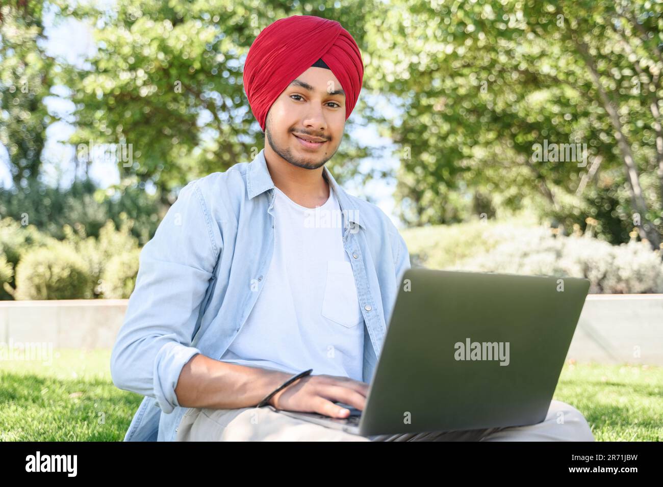 Male Indian student wearing red traditional national turban using ...