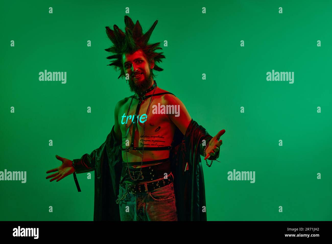 Expressive young man, rock musician, punk with neon filter on body ...