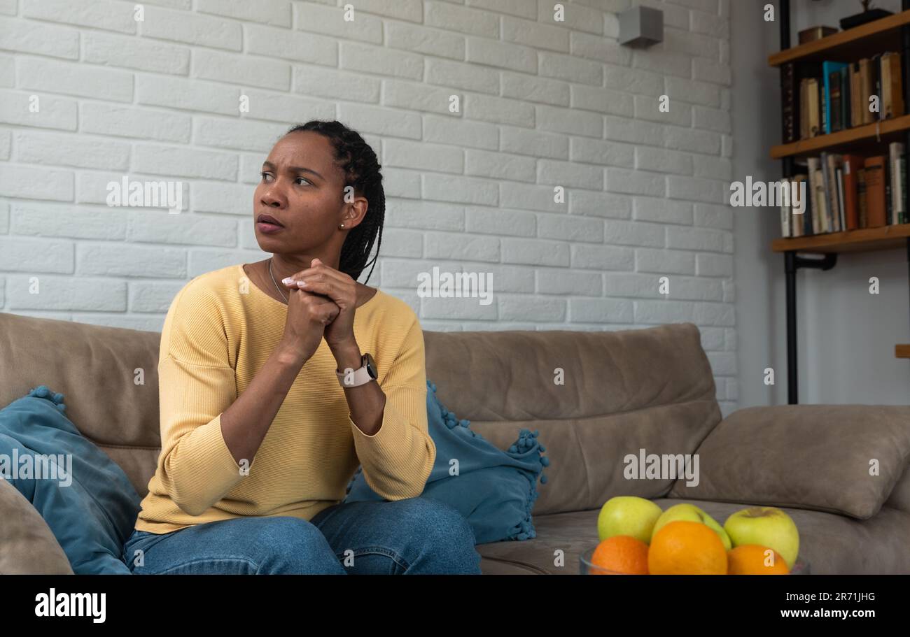 Young african american woman sitting on sofa scared and scared looking ...