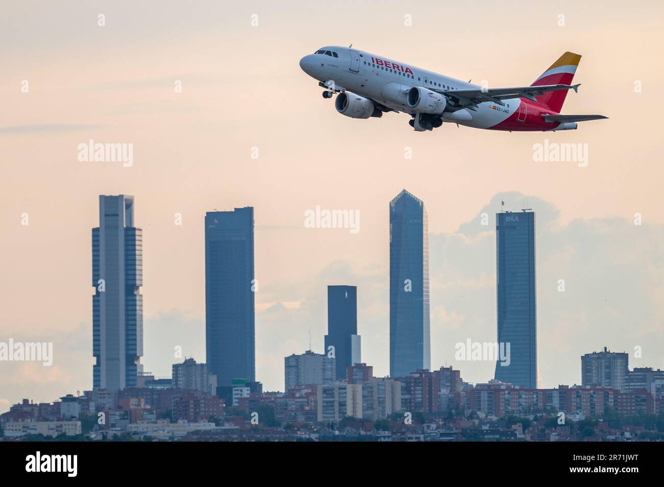 An Airbus A319 of Iberia comercial flight flies over the skyscrapers of ...