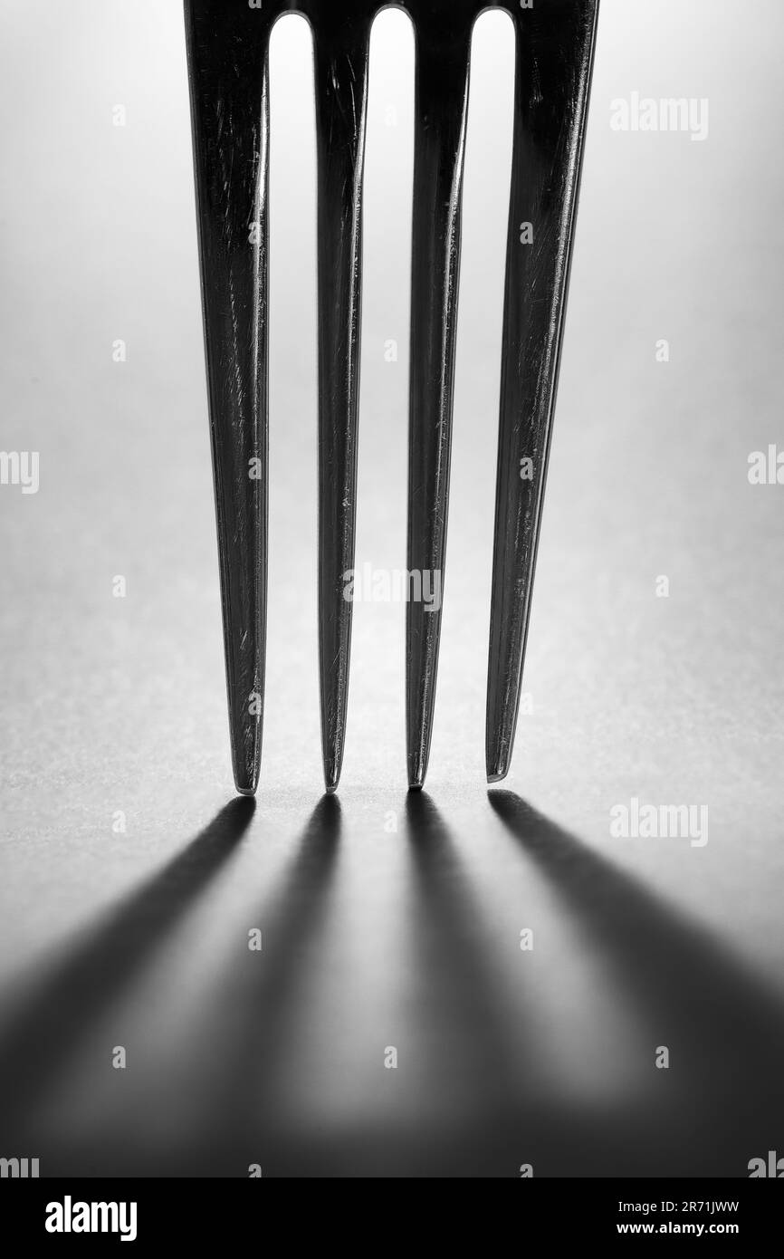Minimalist image of a dinner fork with shadows, all isolated against a ...