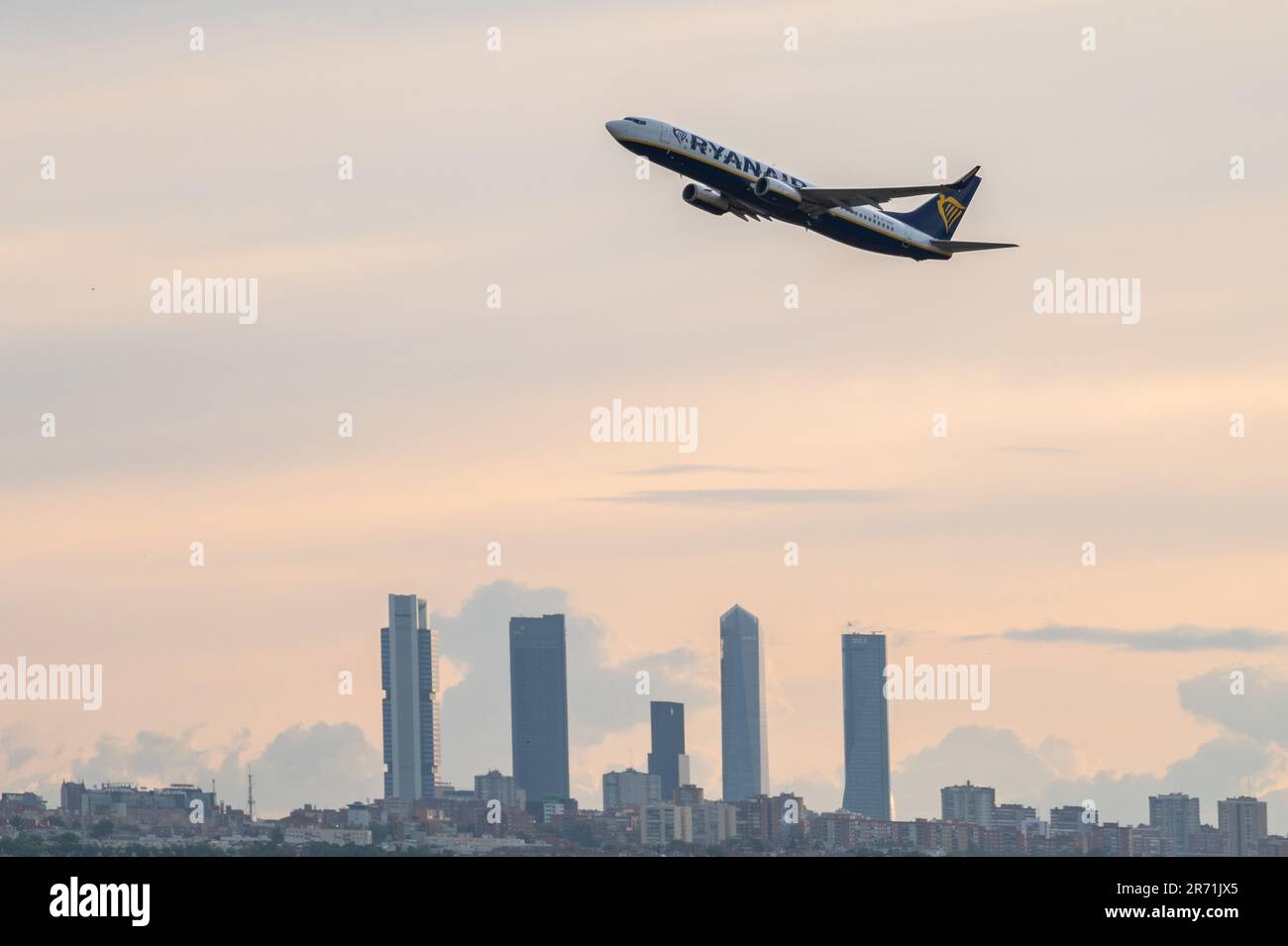 A Boeing 737 of Ryanair comercial flight flies over the skyscrapers of ...