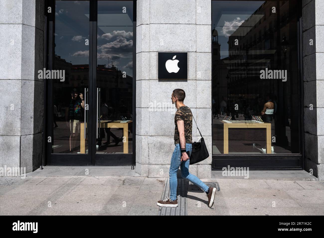 A man heading to an Apple store in downtown Madrid Stock Photo - Alamy