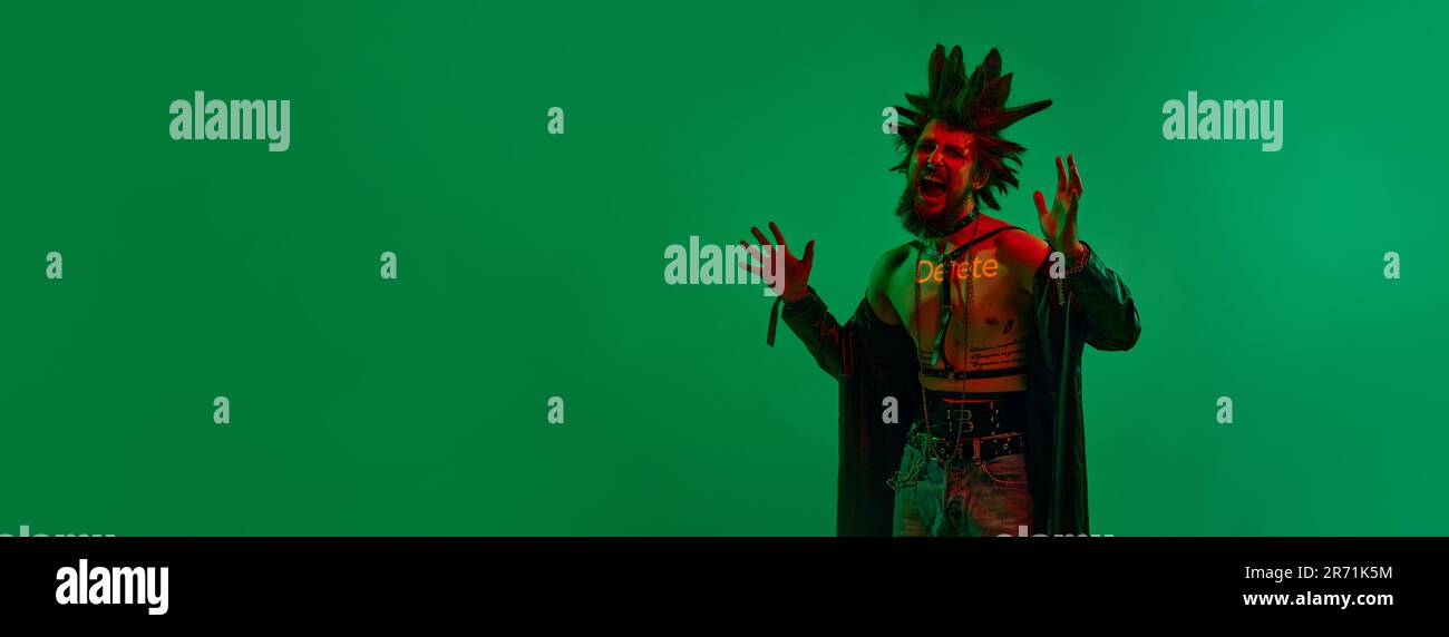 Emotional young man, punk with extraordinary hairstyle and makeup ...