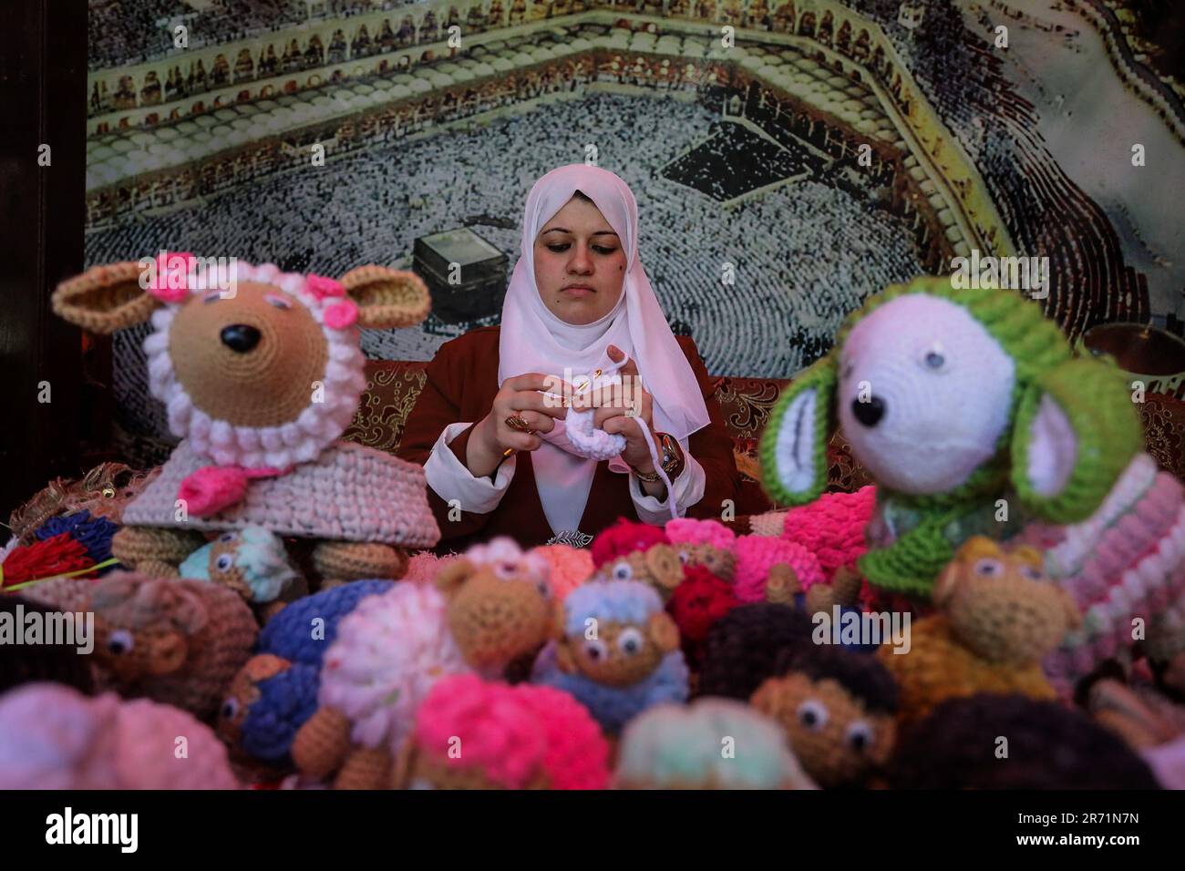 A Palestinian woman, Reham Shurrab, works on weaving sheep dolls in preparation for the blessed ...