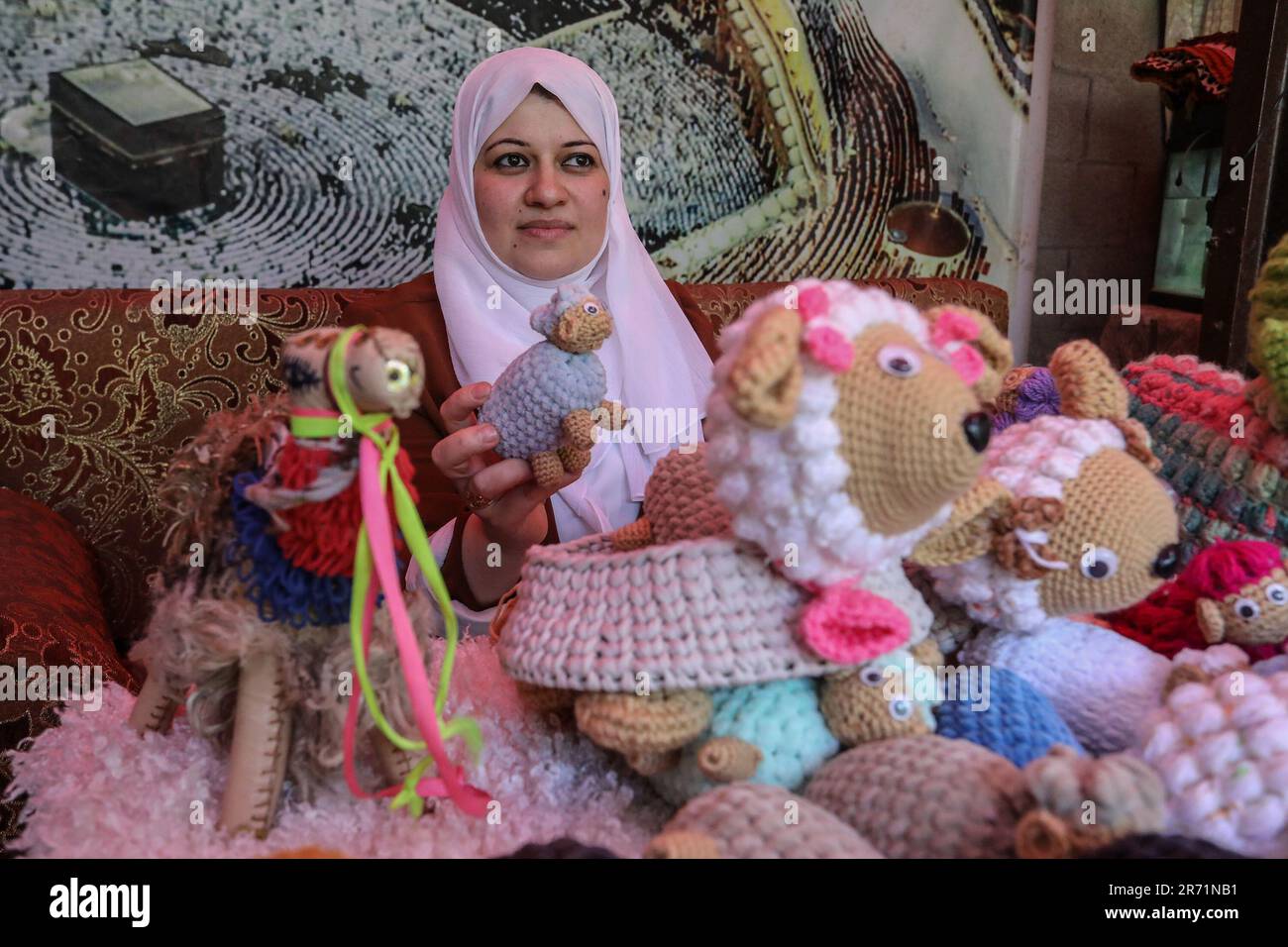 A Palestinian woman, Reham Shurrab, works on weaving sheep dolls in preparation for the blessed ...
