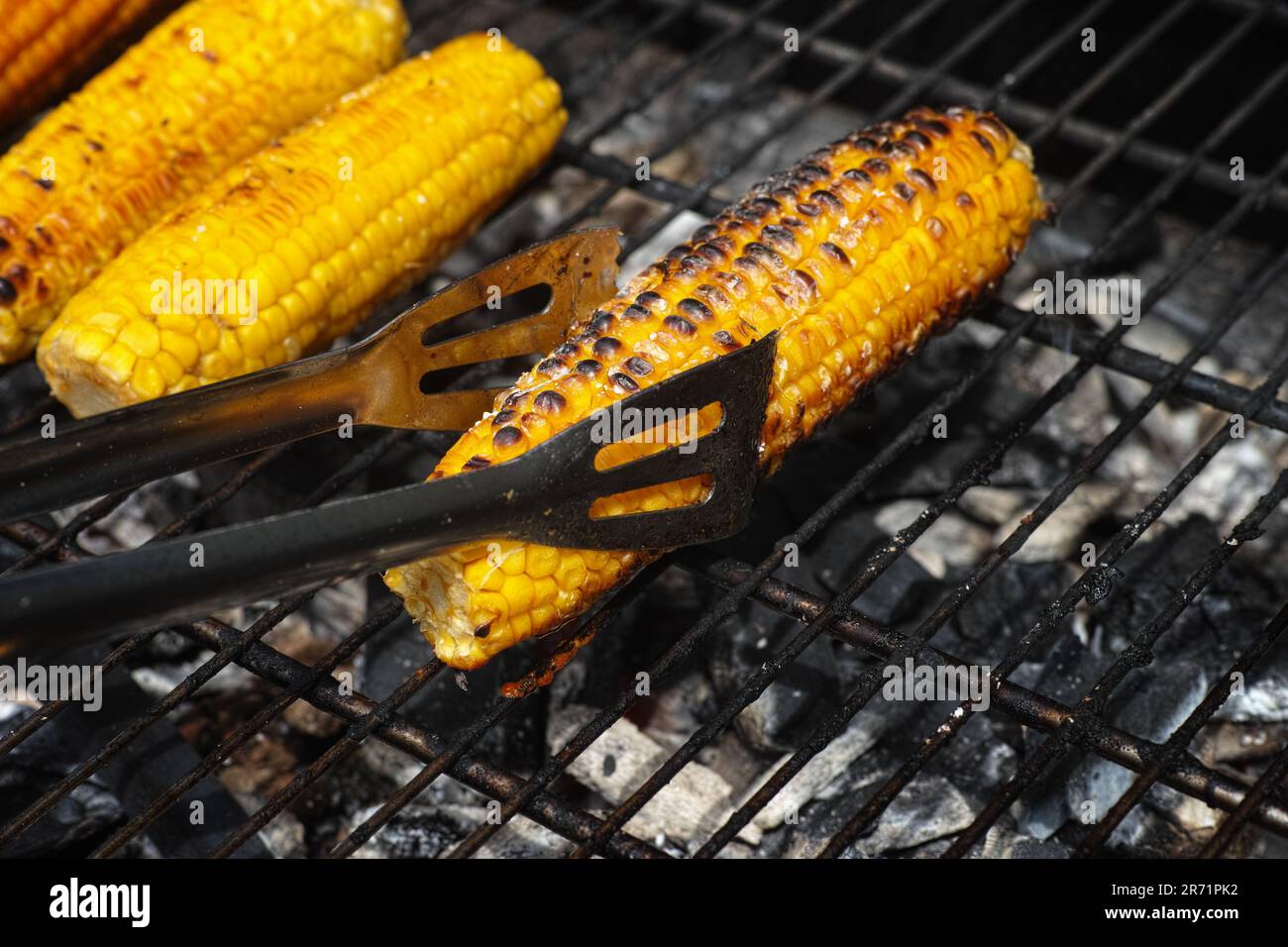 Corn cobs roasting on a bbq grill. Close up Stock Photo - Alamy