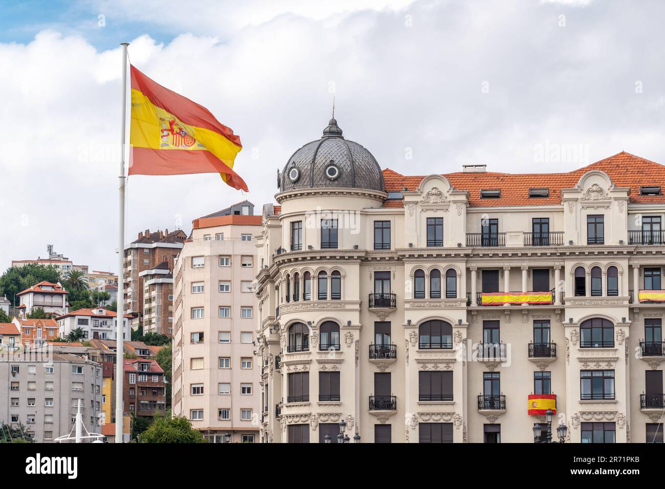 Spanish flag in the Port of Santander. In background beautiful building ...