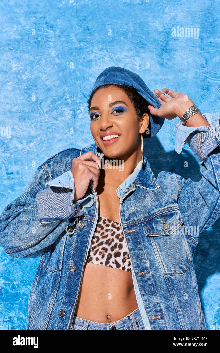 Joyful african american model in denim jacket and top with animal print ...