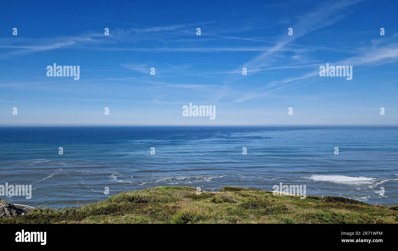 The vast and deep blue Atlantic ocean and sky with clear white clouds ...