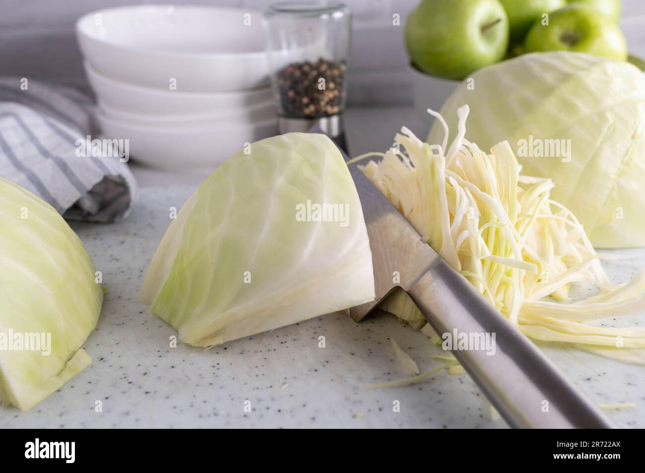 Chopped white cabbage on a cutting board on kitchen counter with ...