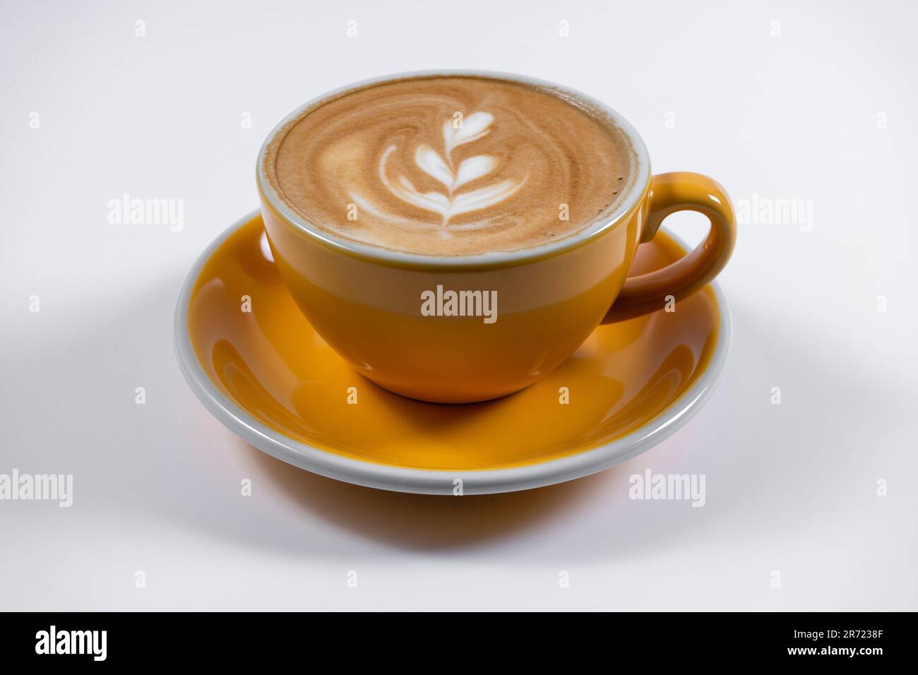 hot coffee latte with foam in yellow ceramic cup on white background ...