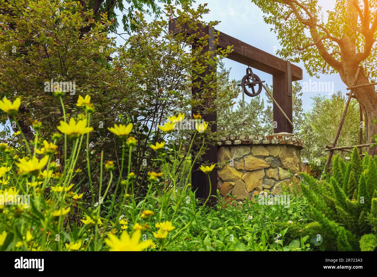 Beautiful artesian well made by stones and wheel pulley with metal ...