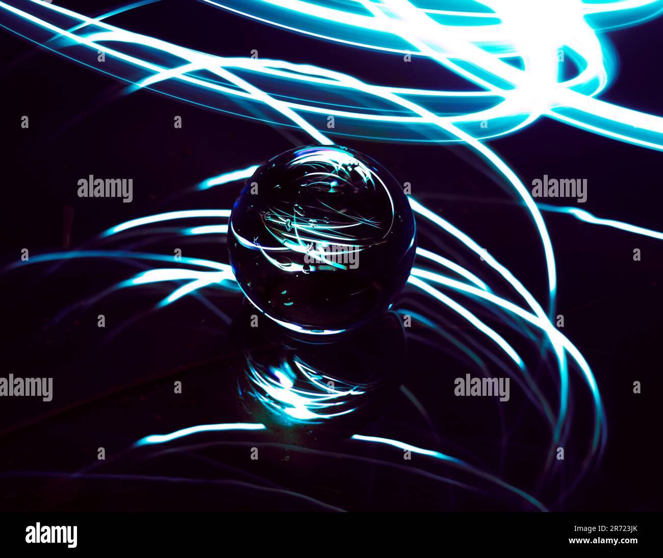 A high-resolution image of a glass marble illuminated by a shimmering ...