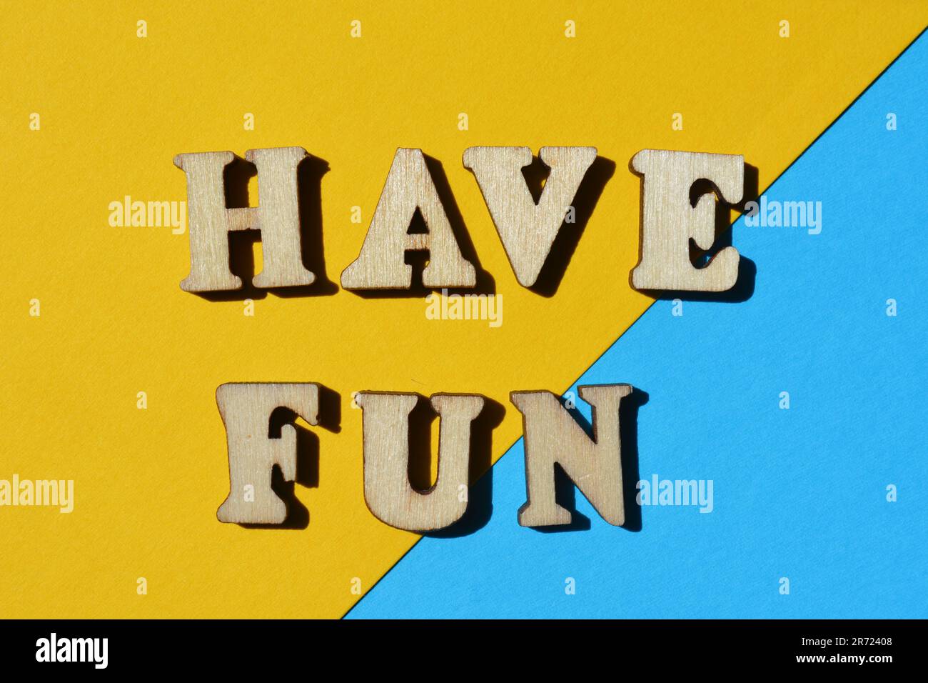 Have Fun, words in wooden alphabet letters isolated on blue and yellow ...