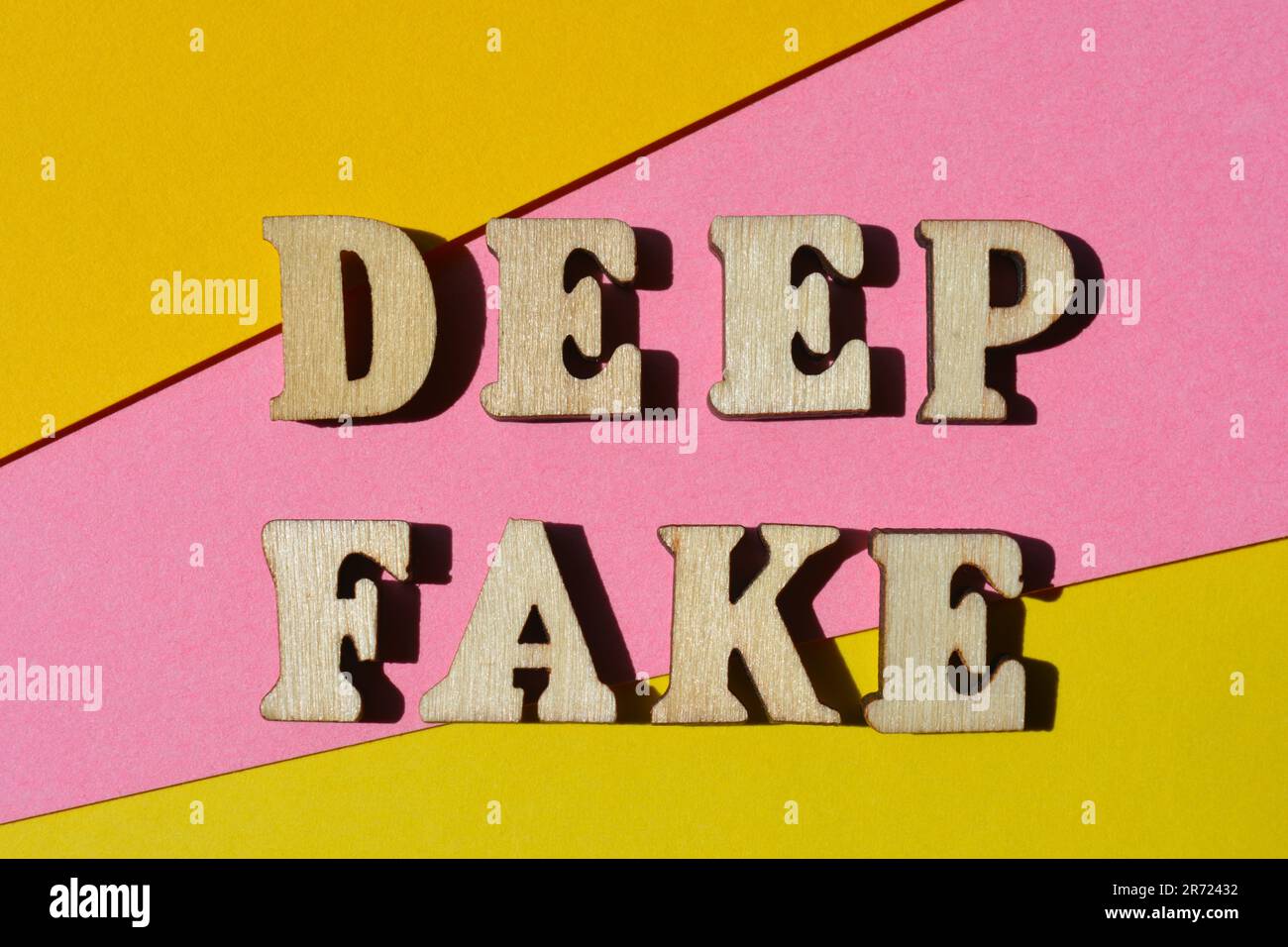 Deep Fake, words in wooden alphabet letters isolated on pink and yellow ...