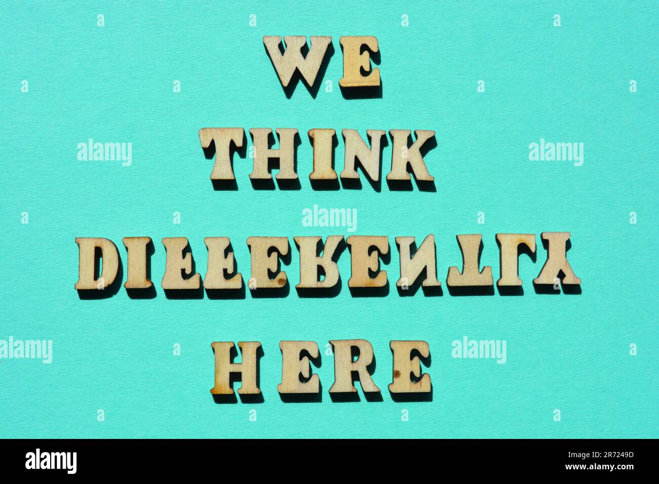 We Think Differently Here, words in wooden alphabet letters isolated on ...