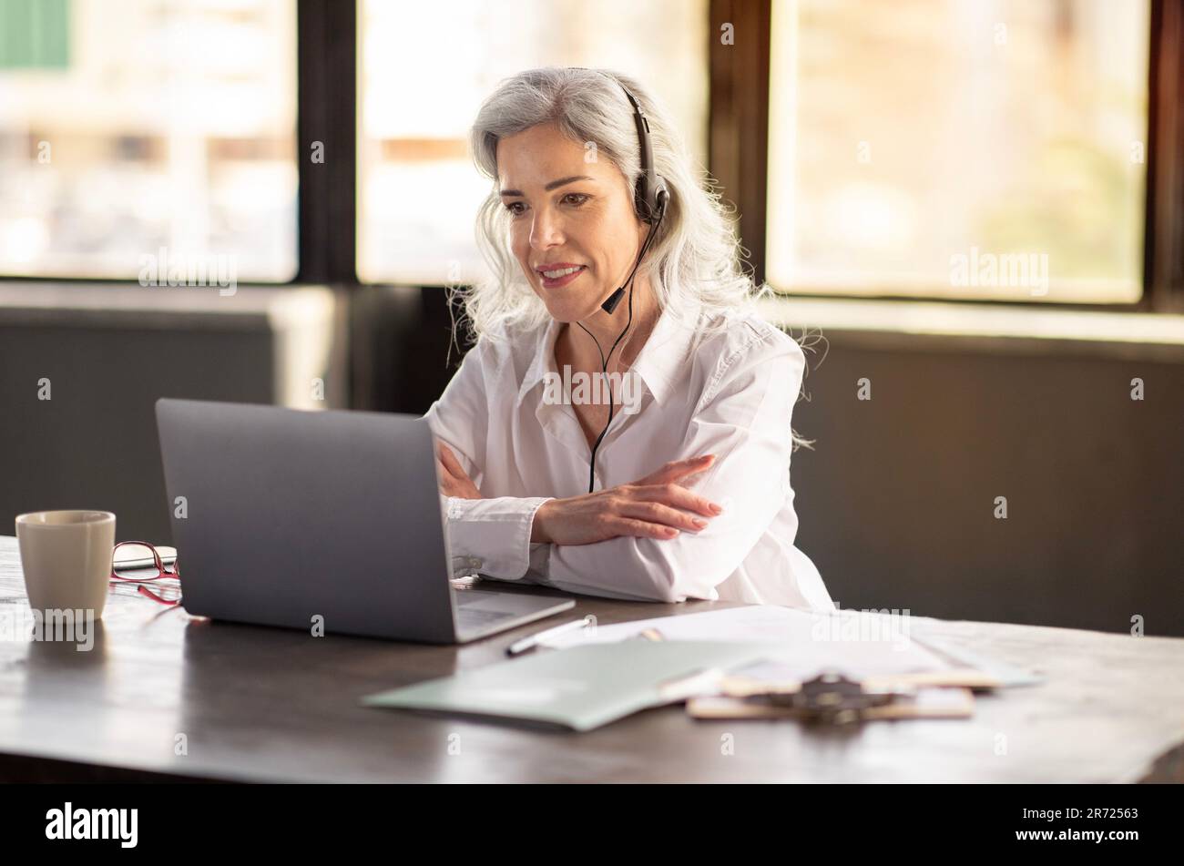 Professional Woman Engaged In Video Call Wearing Headset In Office ...