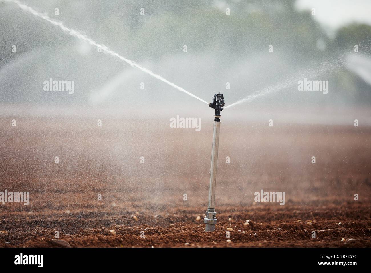 Agricultural irrigation equipment spraying water on dry filed. Themes ...