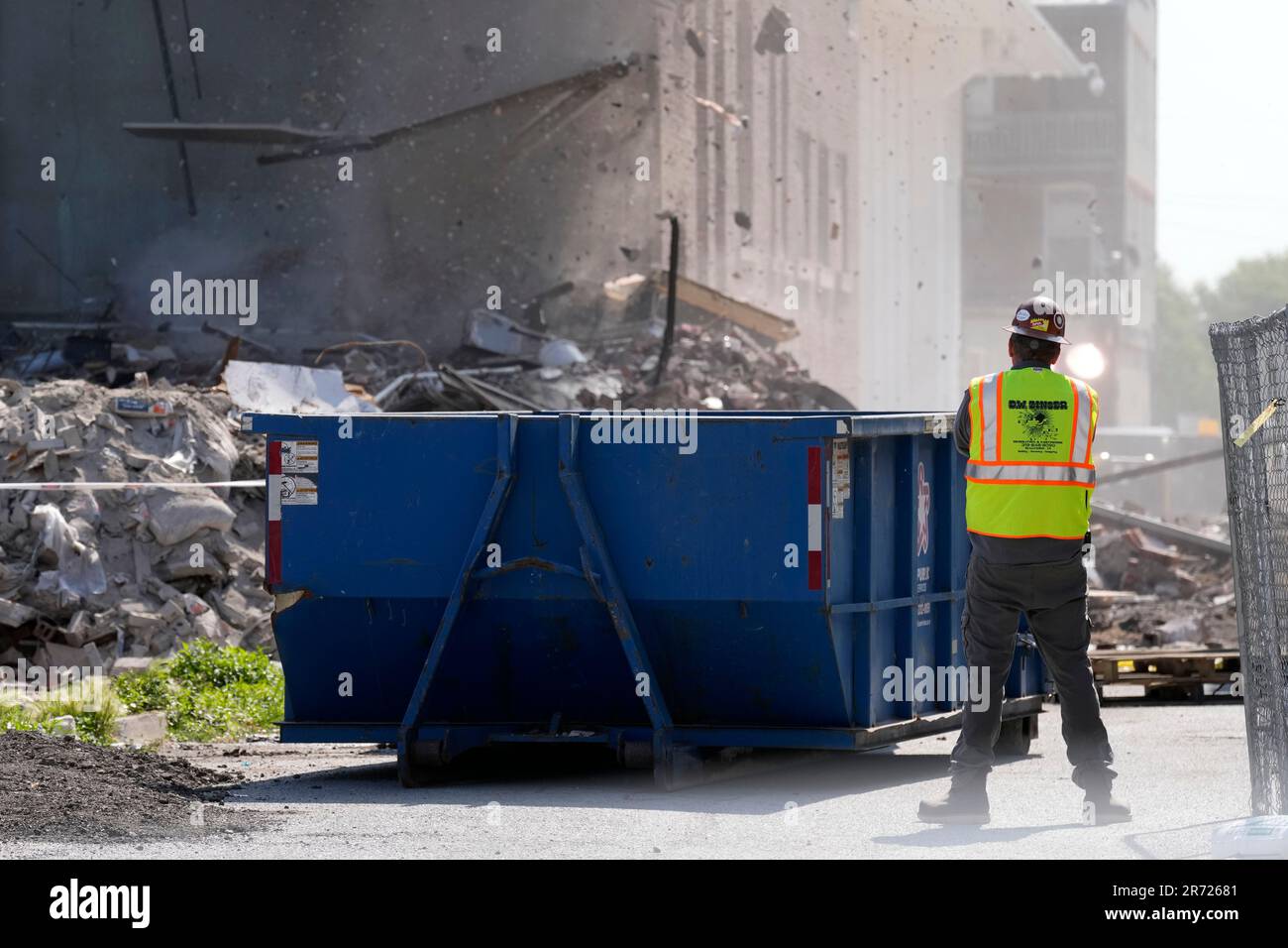 A worker watches debris fall during demolition at the site of a ...