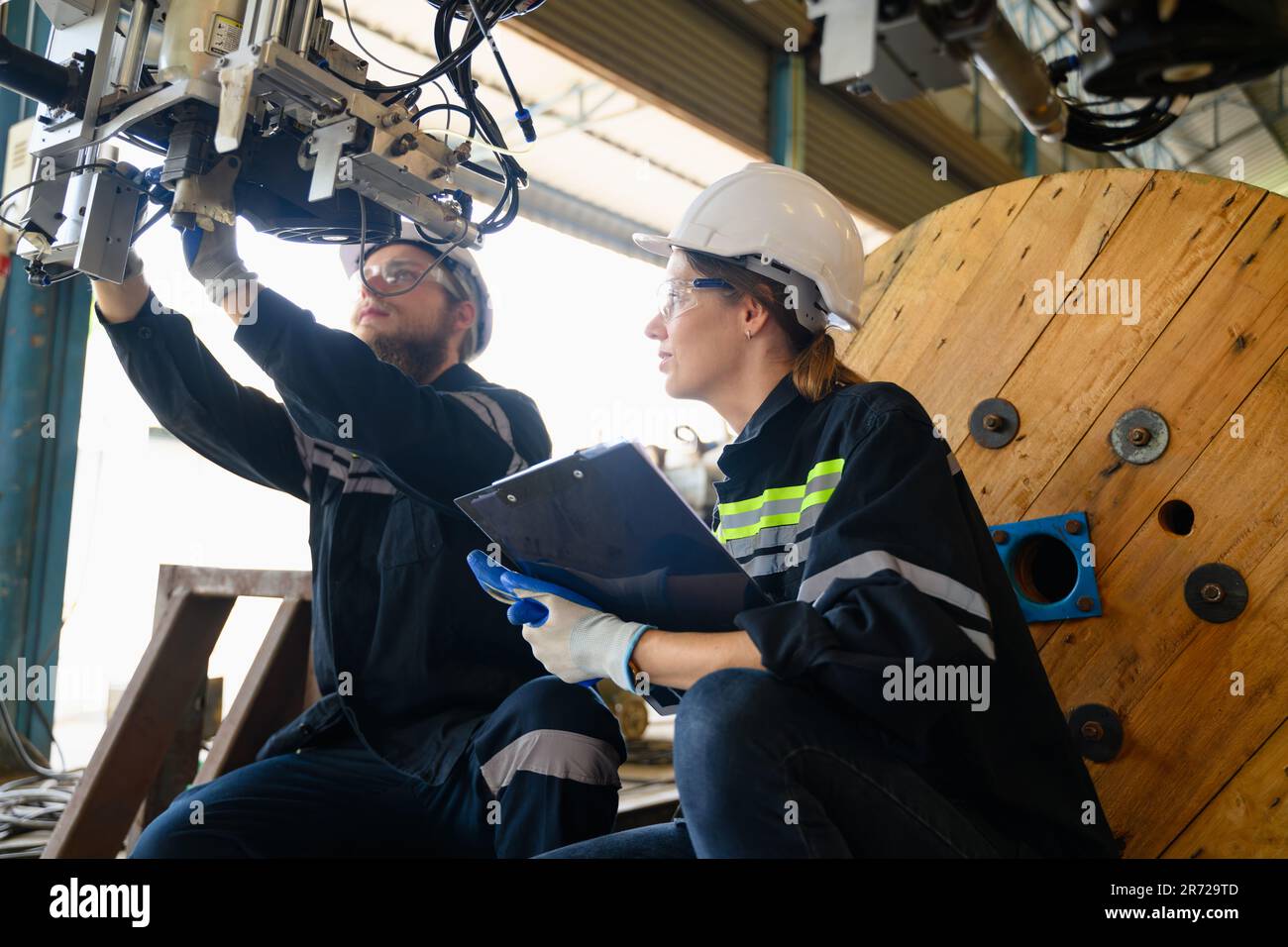 Mechanical engineers repairing engine machine at factory Stock Photo ...