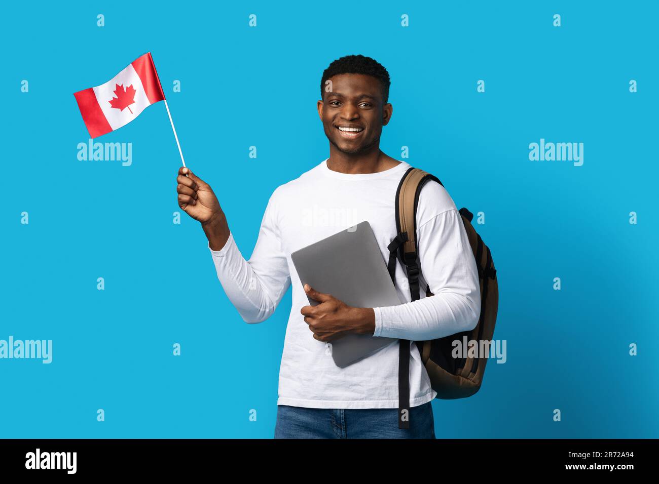 Positive african guy student holding laptop and Canadian flag Stock ...