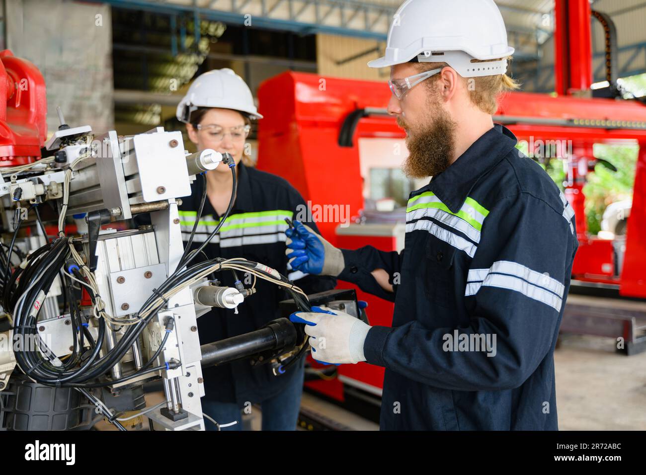 Mechanical engineers repairing engine machine at factory Stock Photo ...