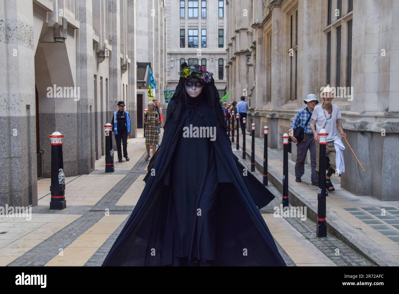 London, UK. 12th June, 2023. A climate activist wearing a black costume ...
