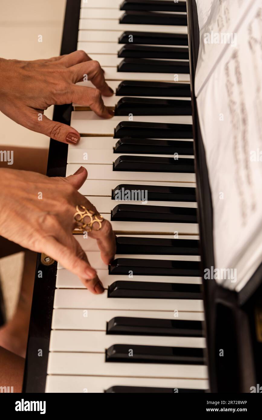 A female musician seated at a grand piano playing a melodic tune, with ...